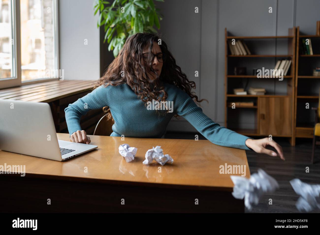 Stressed hysterical young woman throwing crumpled paper, having nervous ...