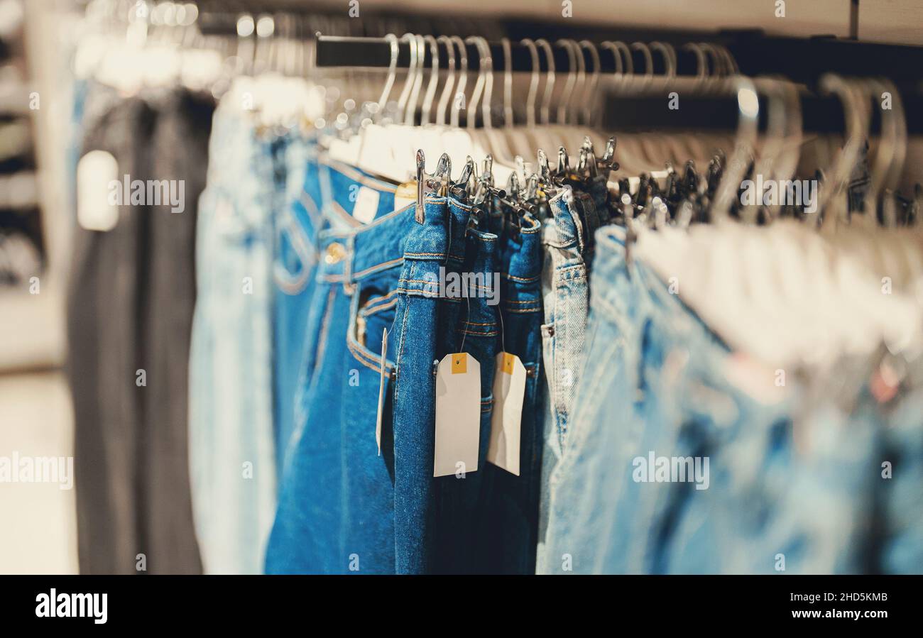 Rack with jeans in clothing store Stock Photo - Alamy