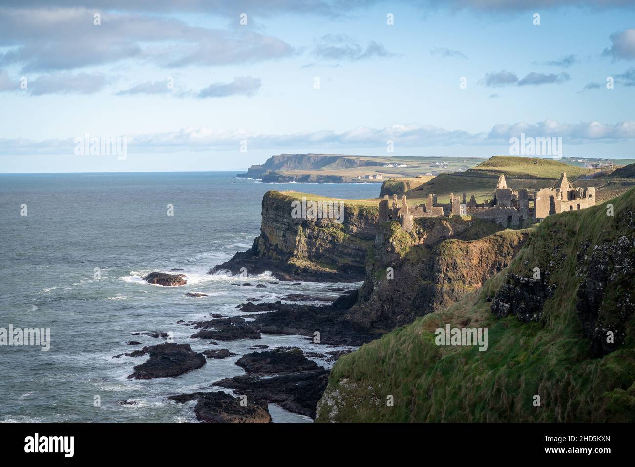The ruins of Dunluce Castle on the edge of s sea cliff on the coast of ...