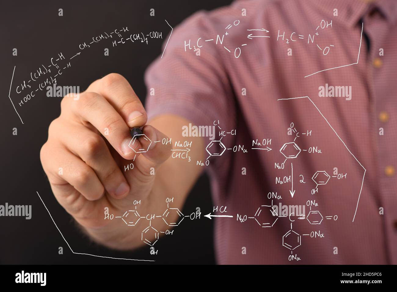 Man hand draws a reaction diagram of organic chemical compounds on ...