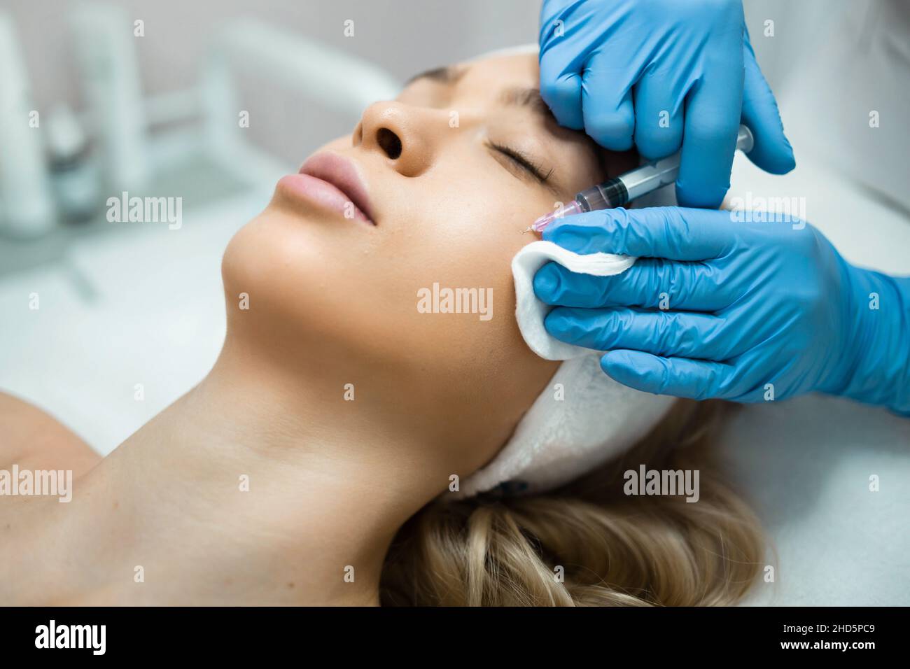 Woman getting cosmetic injection of botox in cheek. Anti-aging ...