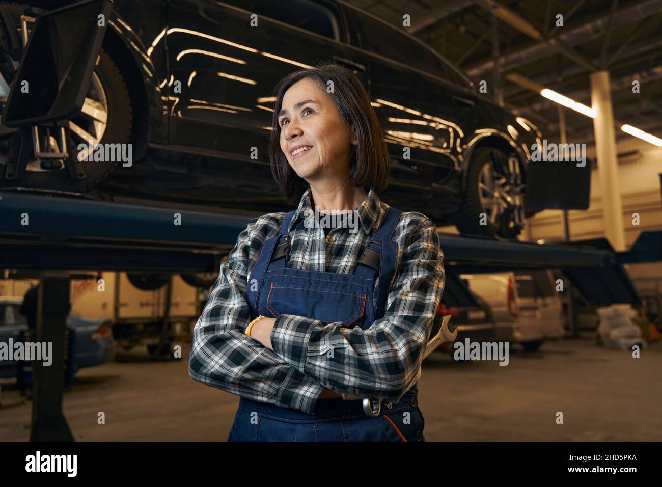 Proud female mechanic happily posing at her workplace Stock Photo - Alamy