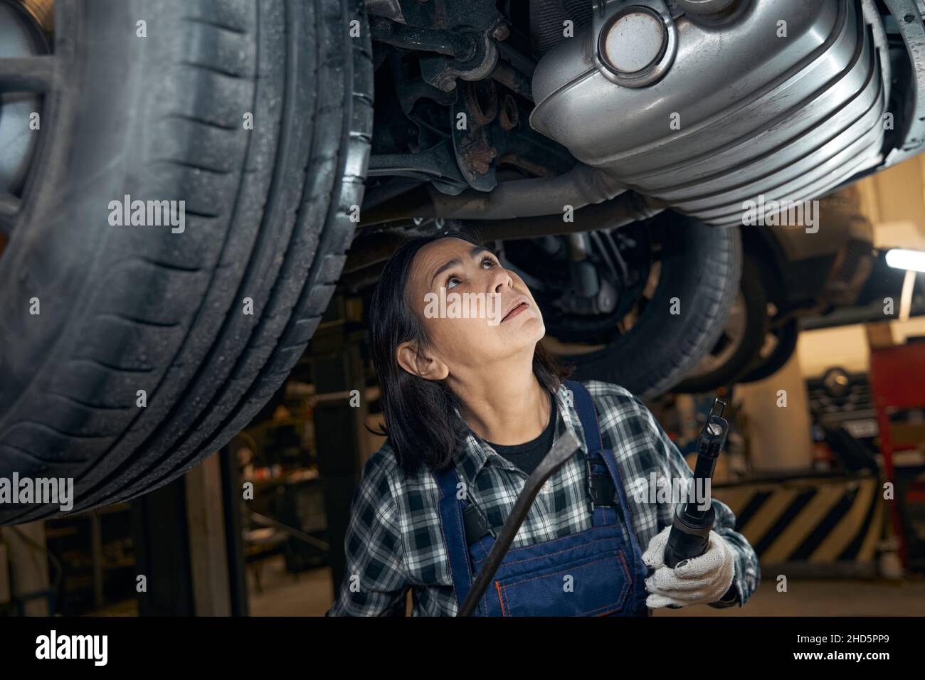 Certified mechanic looking disturbed while fixing a car Stock Photo - Alamy