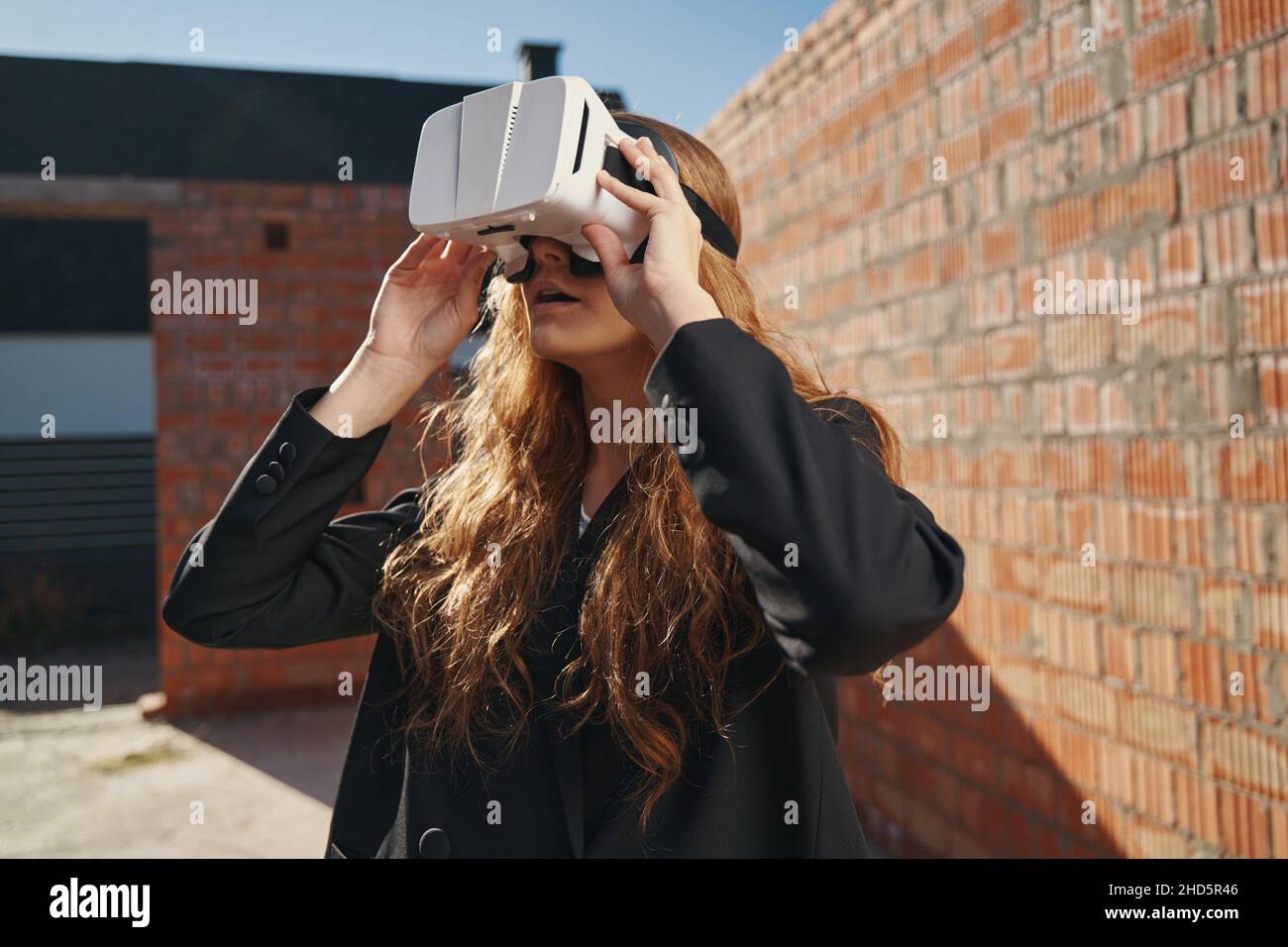 Woman worker looking through VR goggles on construction site Stock ...