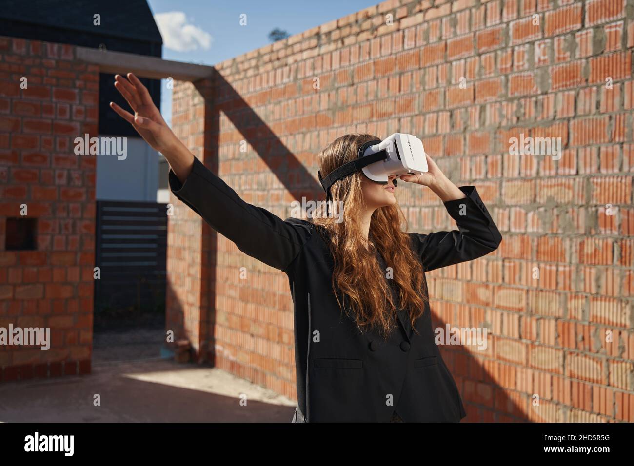 Woman worker looking through VR glasses and stretching out arm Stock ...