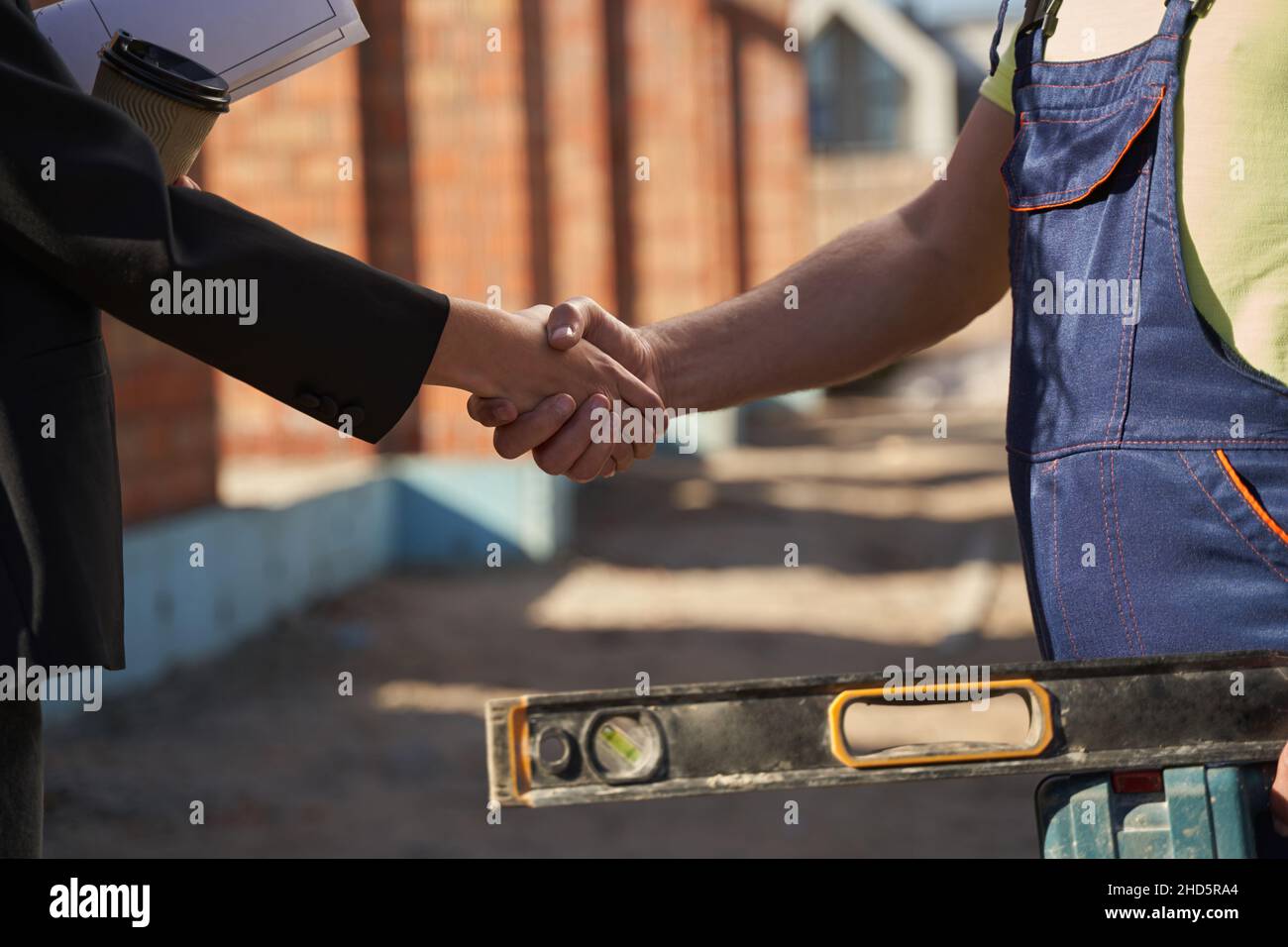 Civil engineer and worker shaking hands on site Stock Photo - Alamy