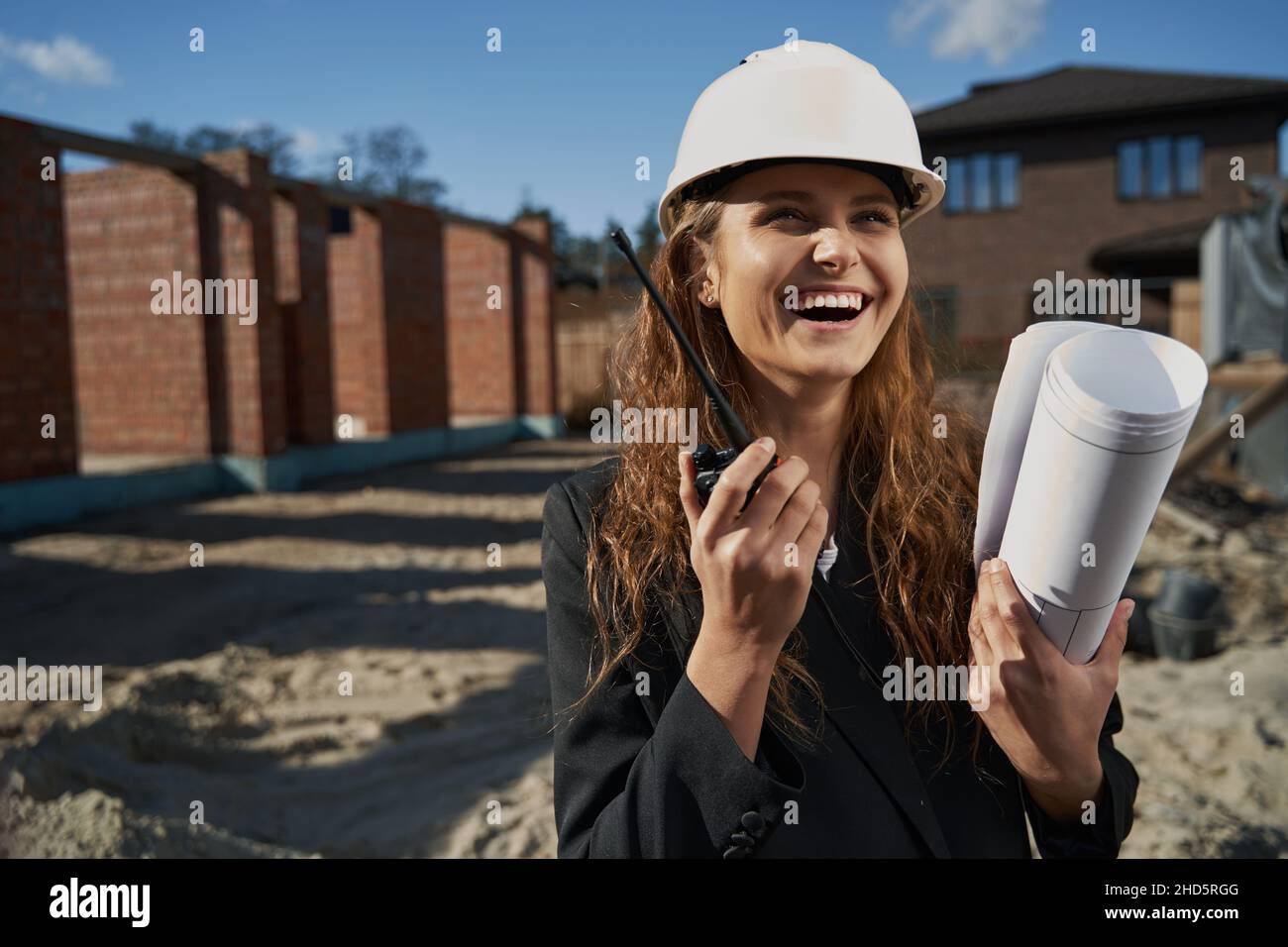 Laughing woman worker with layout talking by radio Stock Photo - Alamy