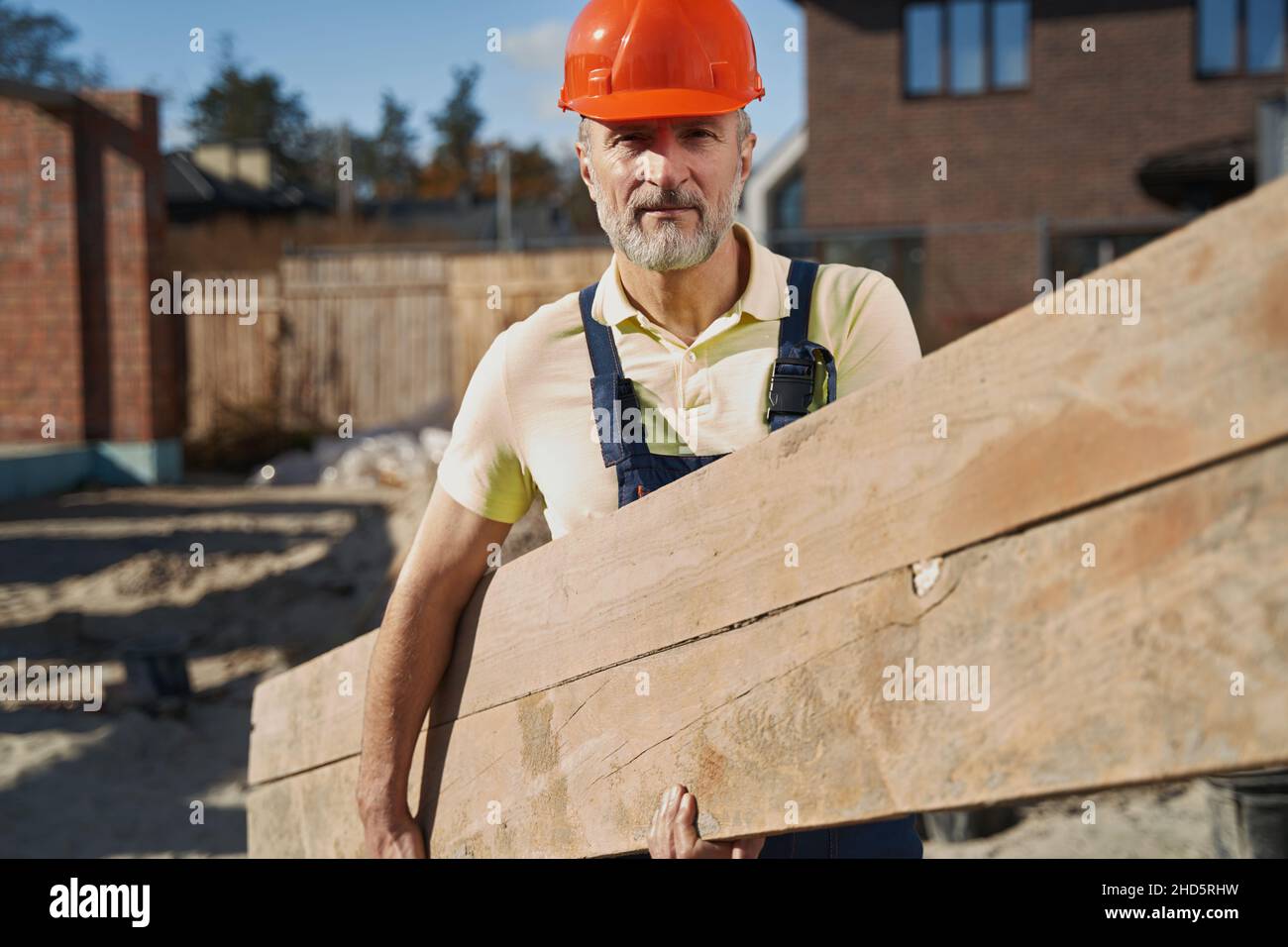 Construction worker with board staring into camera Stock Photo - Alamy