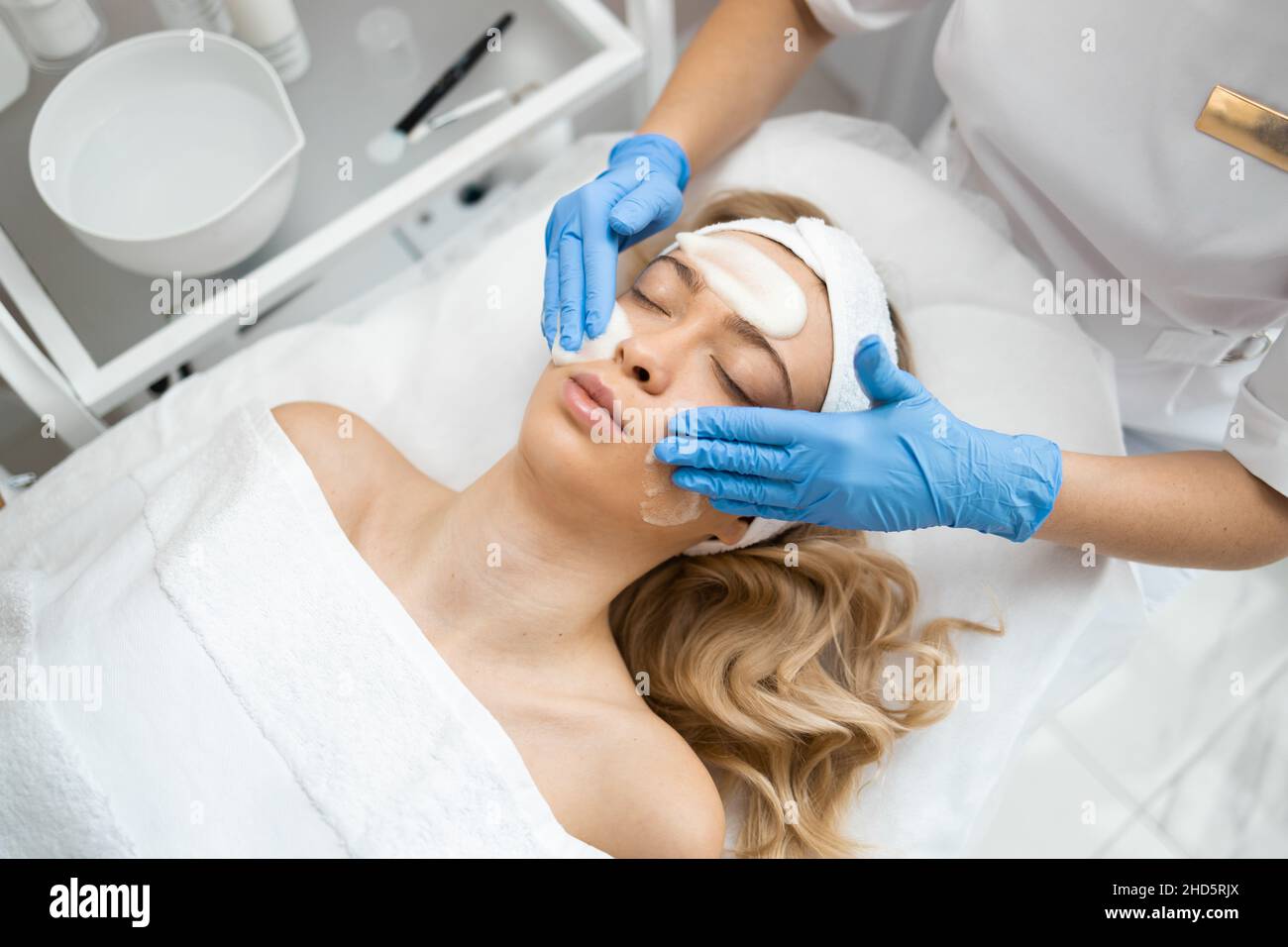 Dermatology Doctor In Gloves Is Applying Facial Cleansing Foam On Woman