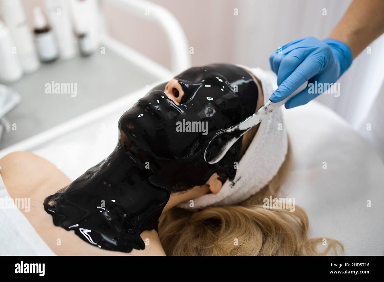 Cosmetologist makes procedure of cleansing and moisturizing the skin ...