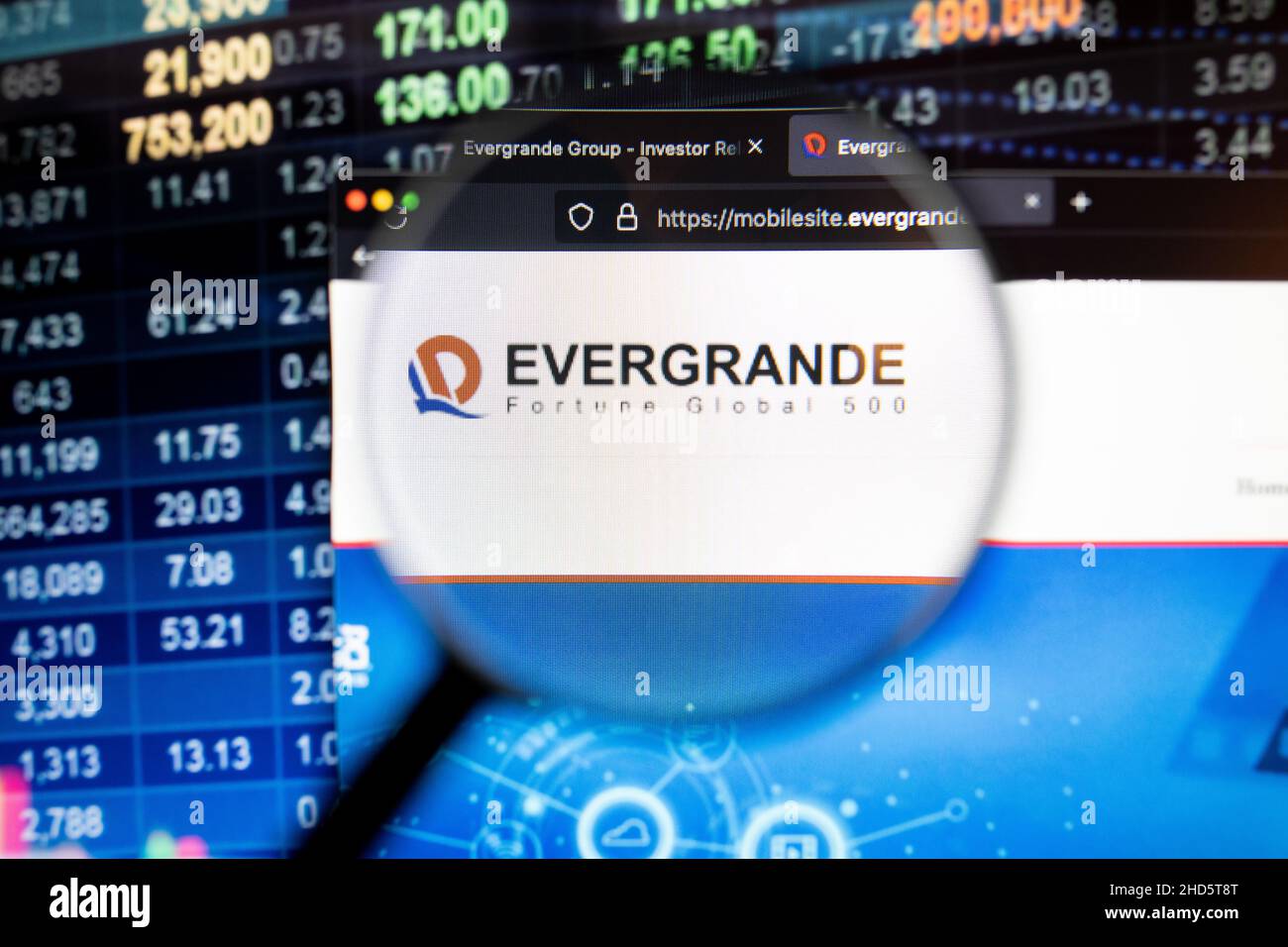 Evergrande company logo on a website with blurry stock market developments in the background ...