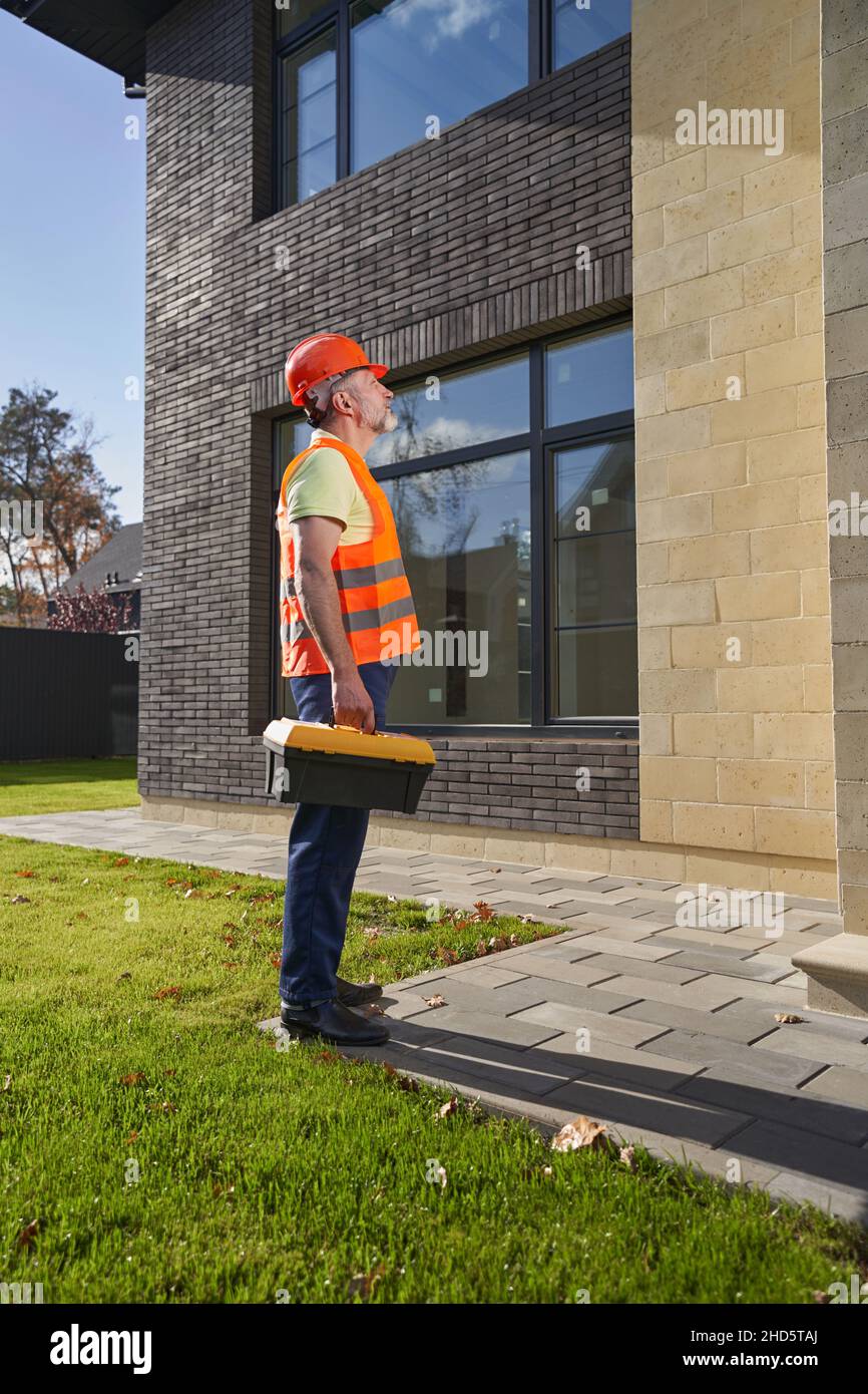 Housebuilder with set of instruments looking at building Stock Photo ...
