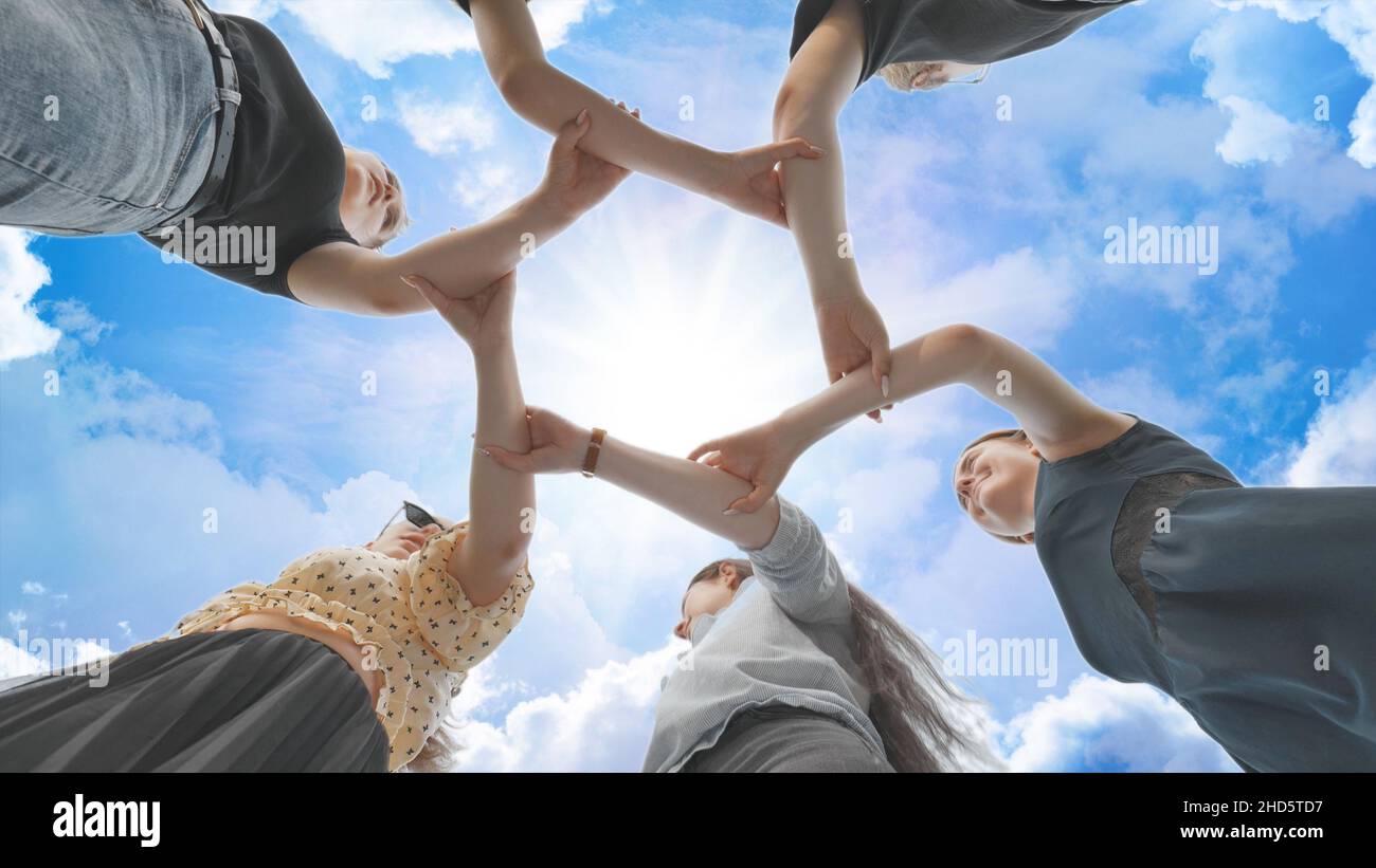 Friends join their hands by the wrist and make a circle against the ...