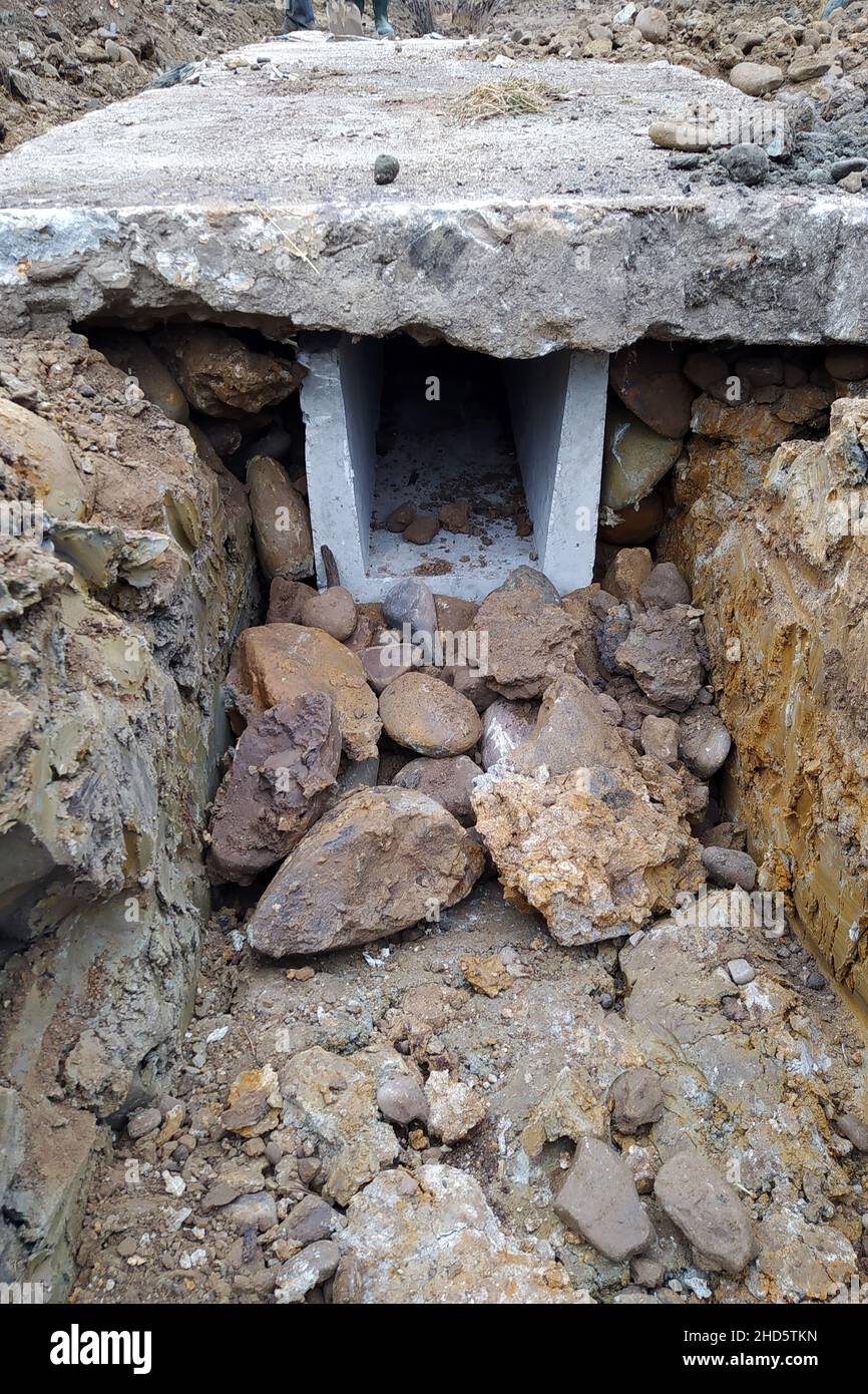 The excavator puts concrete slabs for moving through the gutter ...