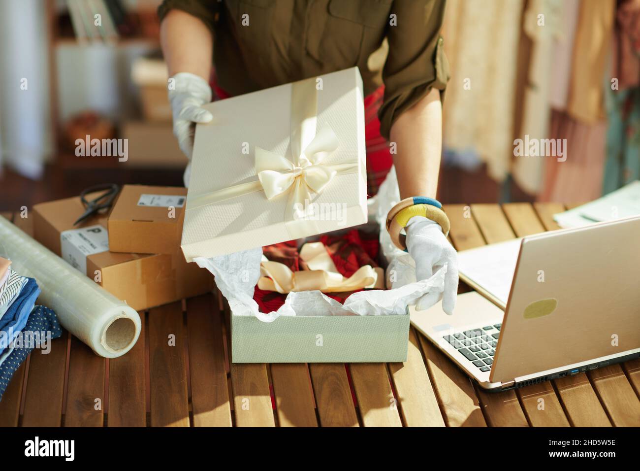 Closeup on small business owner woman in the office packing product for ...