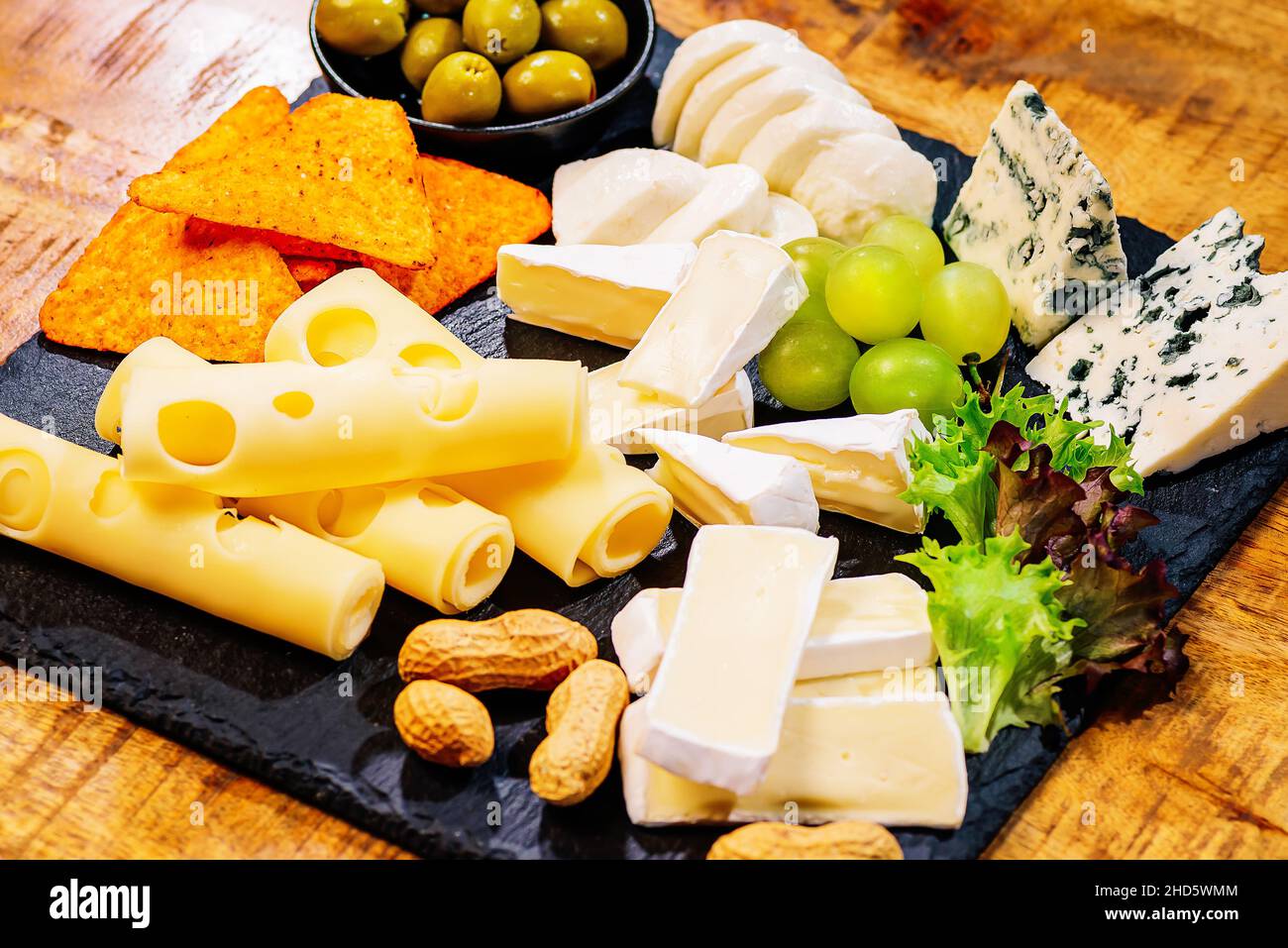 Set of different types of cheese with grapes on black board. Dairy ...