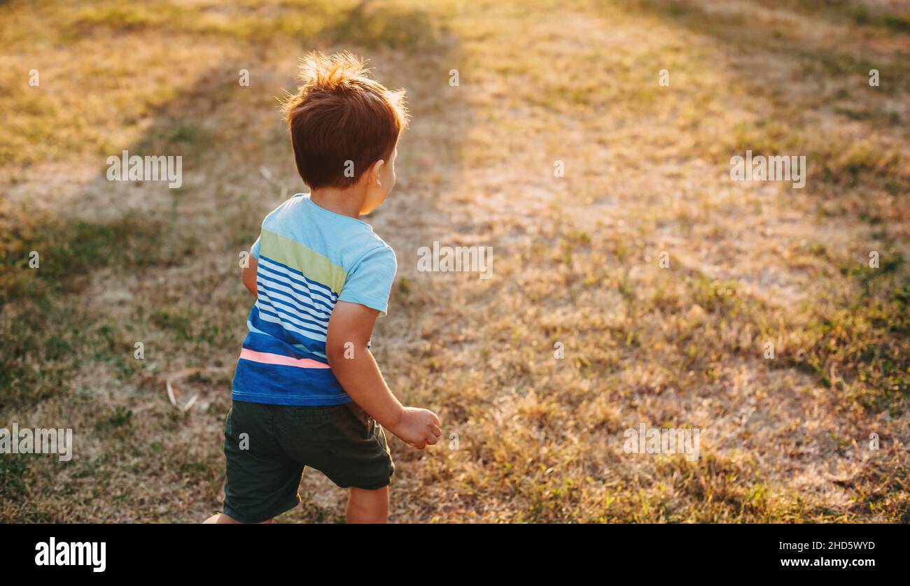 Back view of a little boy running at park. Sunset. Weekend Stock Photo ...