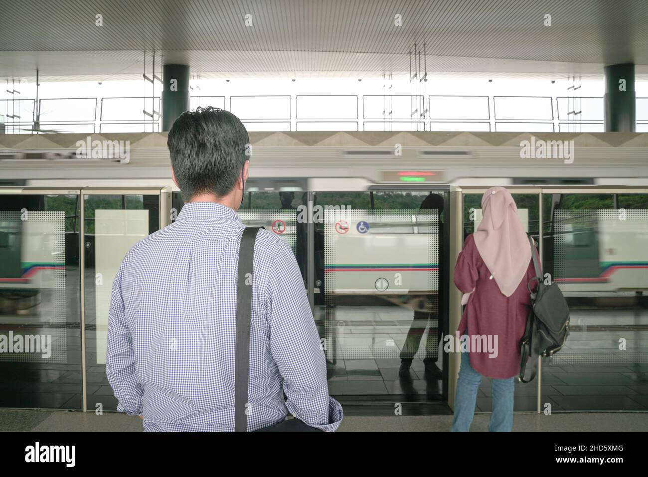 Commuters waiting for train at subway station platform. Back view of ...