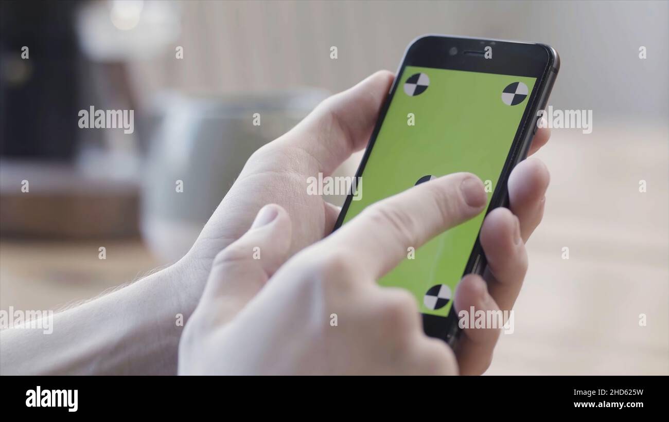 Close up of hands using smartphone with green screen, sliding and ...