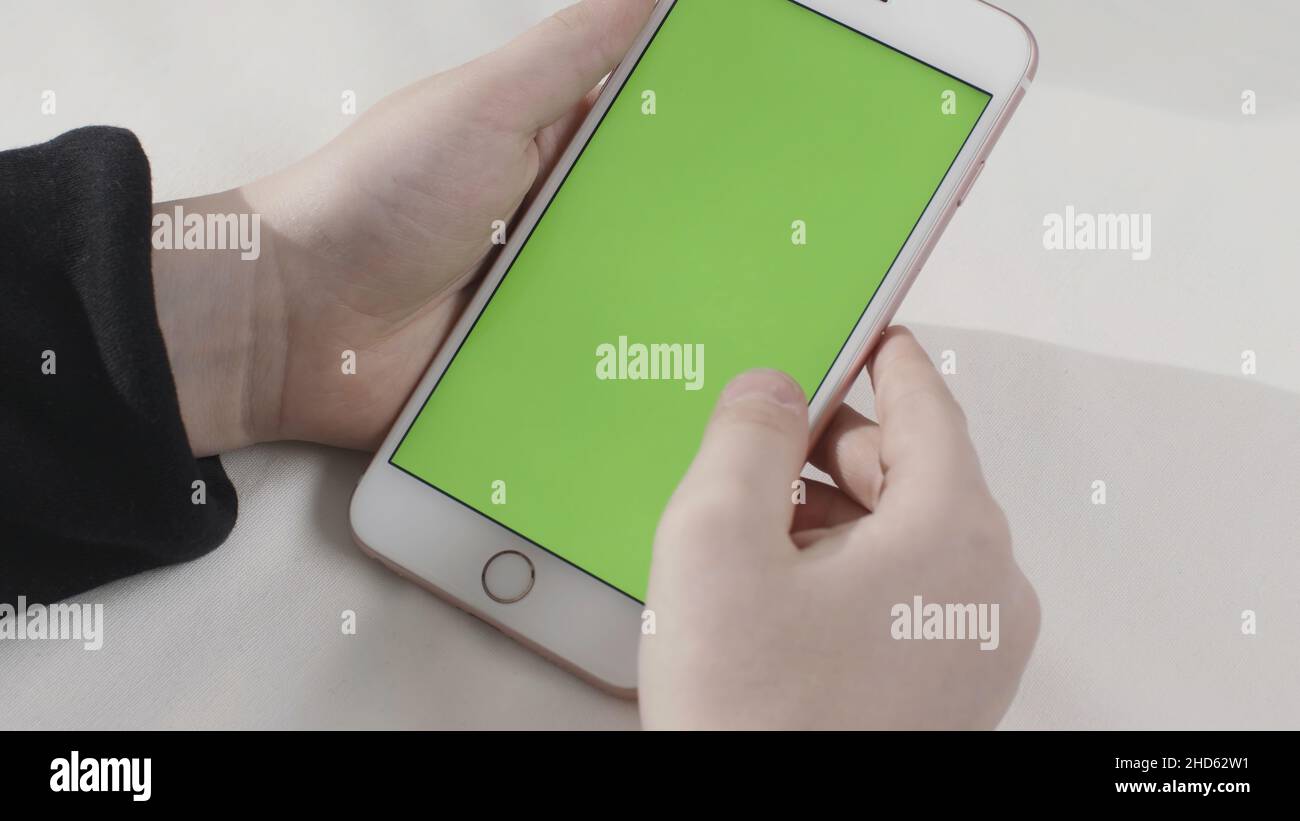 Hand holding touch green screen smart phone on white background. Hand ...