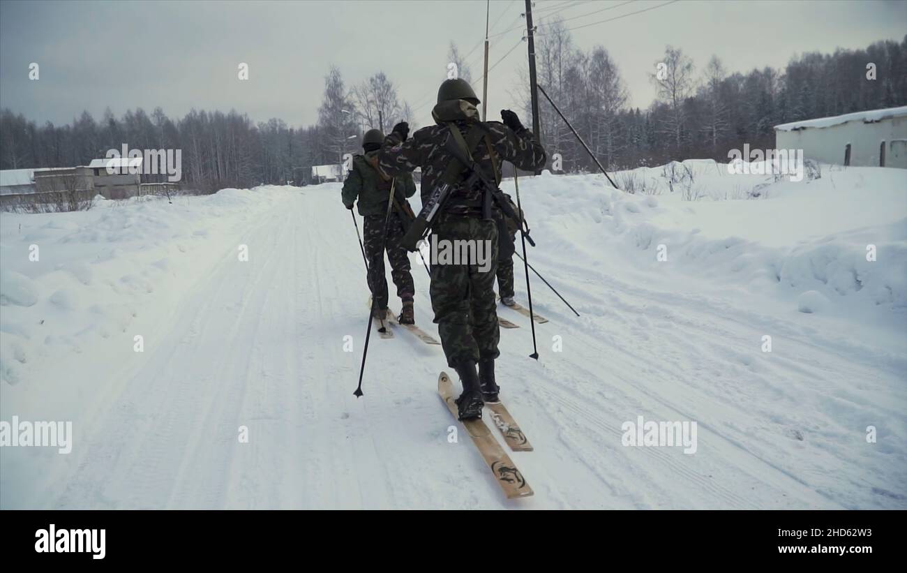 Group of soldiers run on skis in the woods with weapons. Clip. Soldiers ...