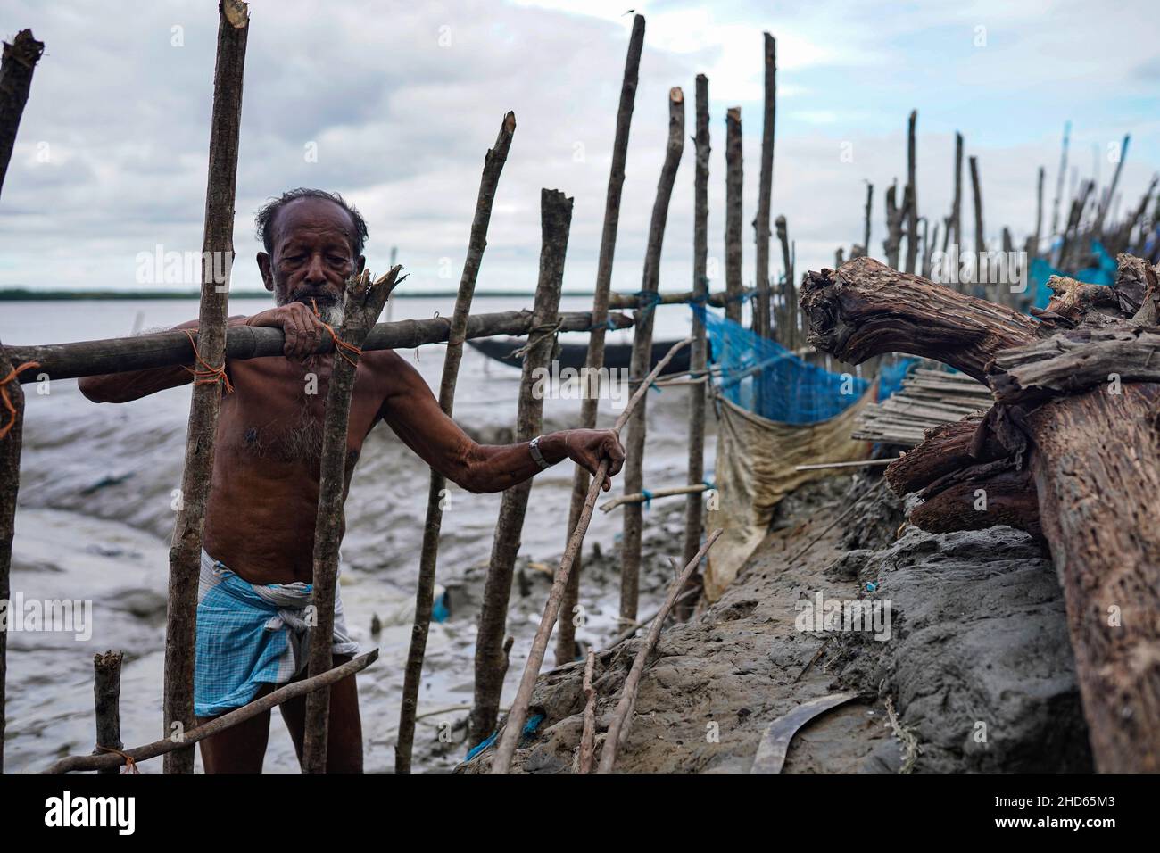 An old man seen re-establishing the fence to protect the embarkment ...