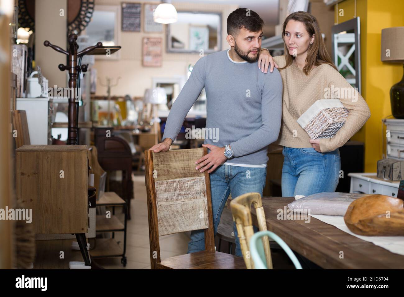Girl with boyfriend choosing vintage chair Stock Photo - Alamy