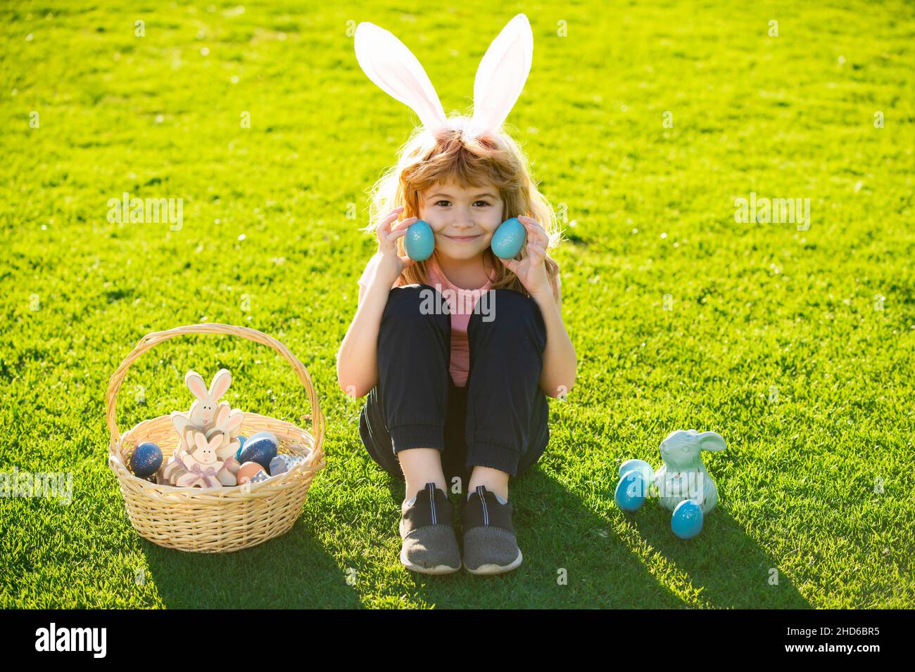 Easter bunny kids. Child boy in bunny Easter ears painting eggs. Funny ...