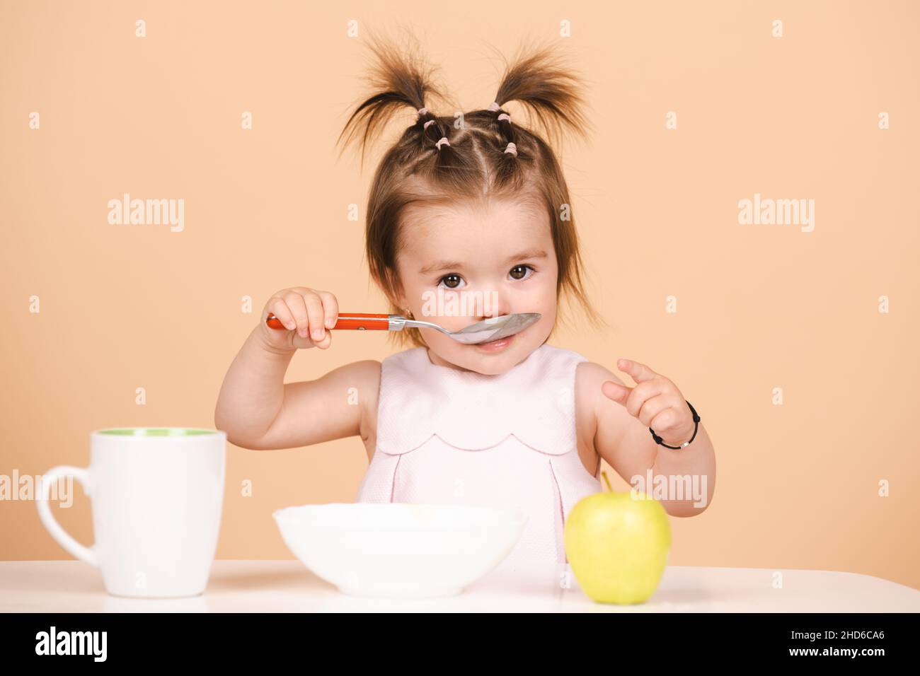 Baby eating kids food. Kid eating healthy food with a spoon at studio ...