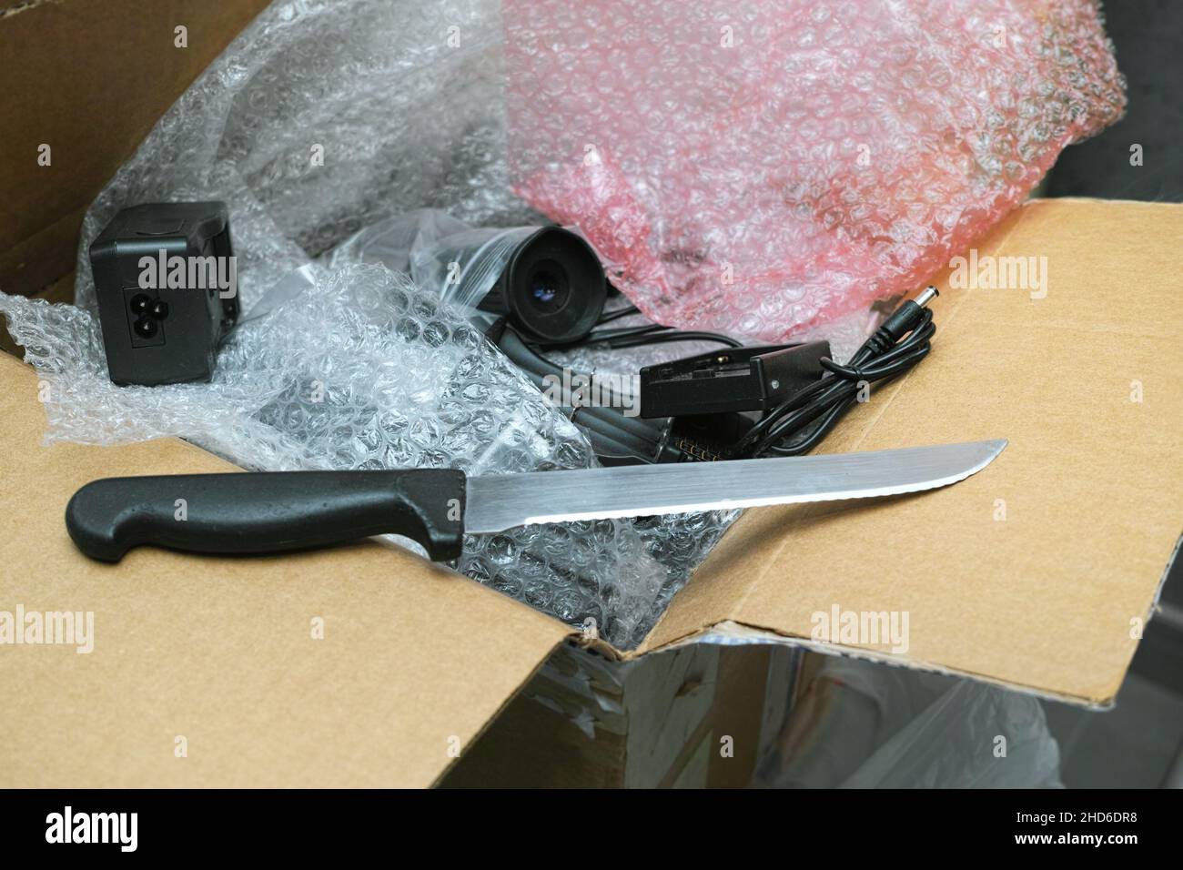 opening a cardboard box delivery with a kitchen knife, indoor close up ...