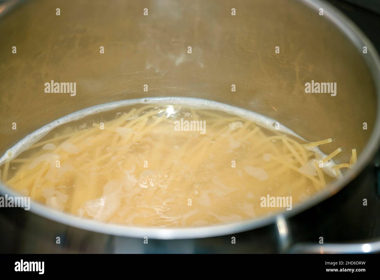 a stainless casserole with spaghetti in boiling water, shallow DOF ...