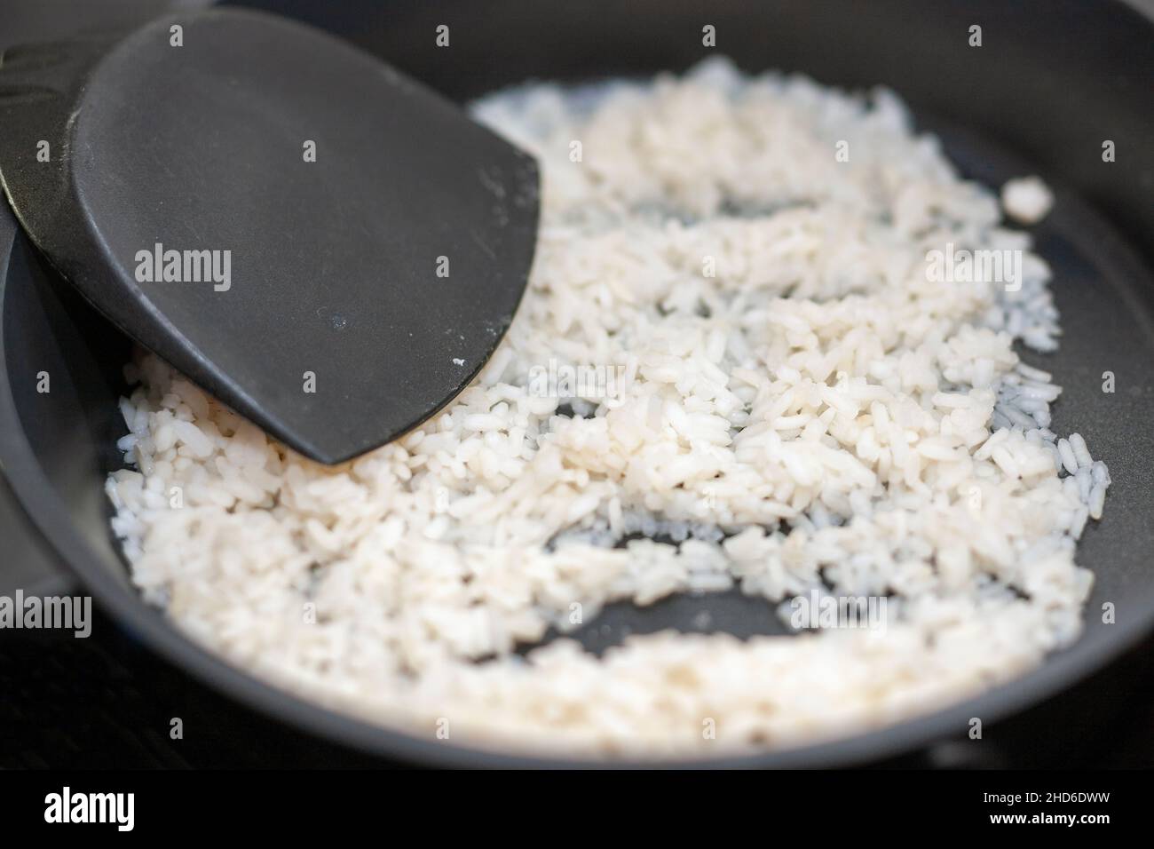 stirring rice on a pan with plastic spoon, indoor closeup Stock Photo ...