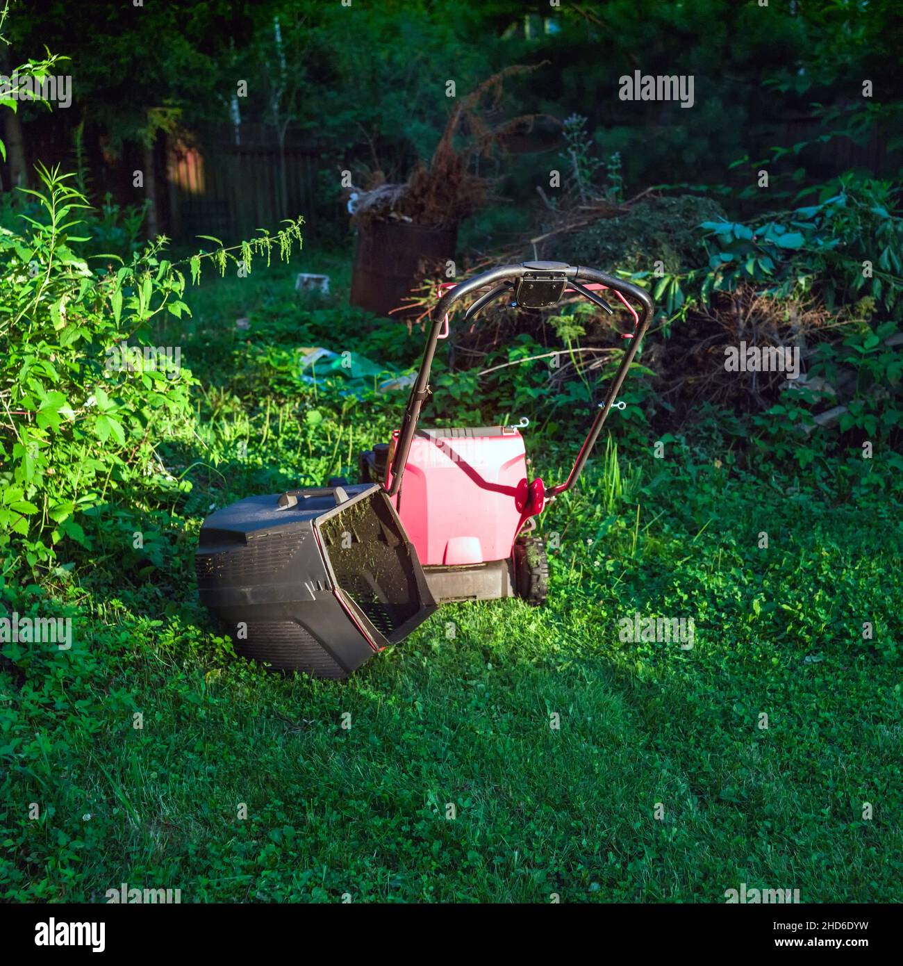 a broken lawn mower abandoned in overgrown part of garden Stock Photo ...