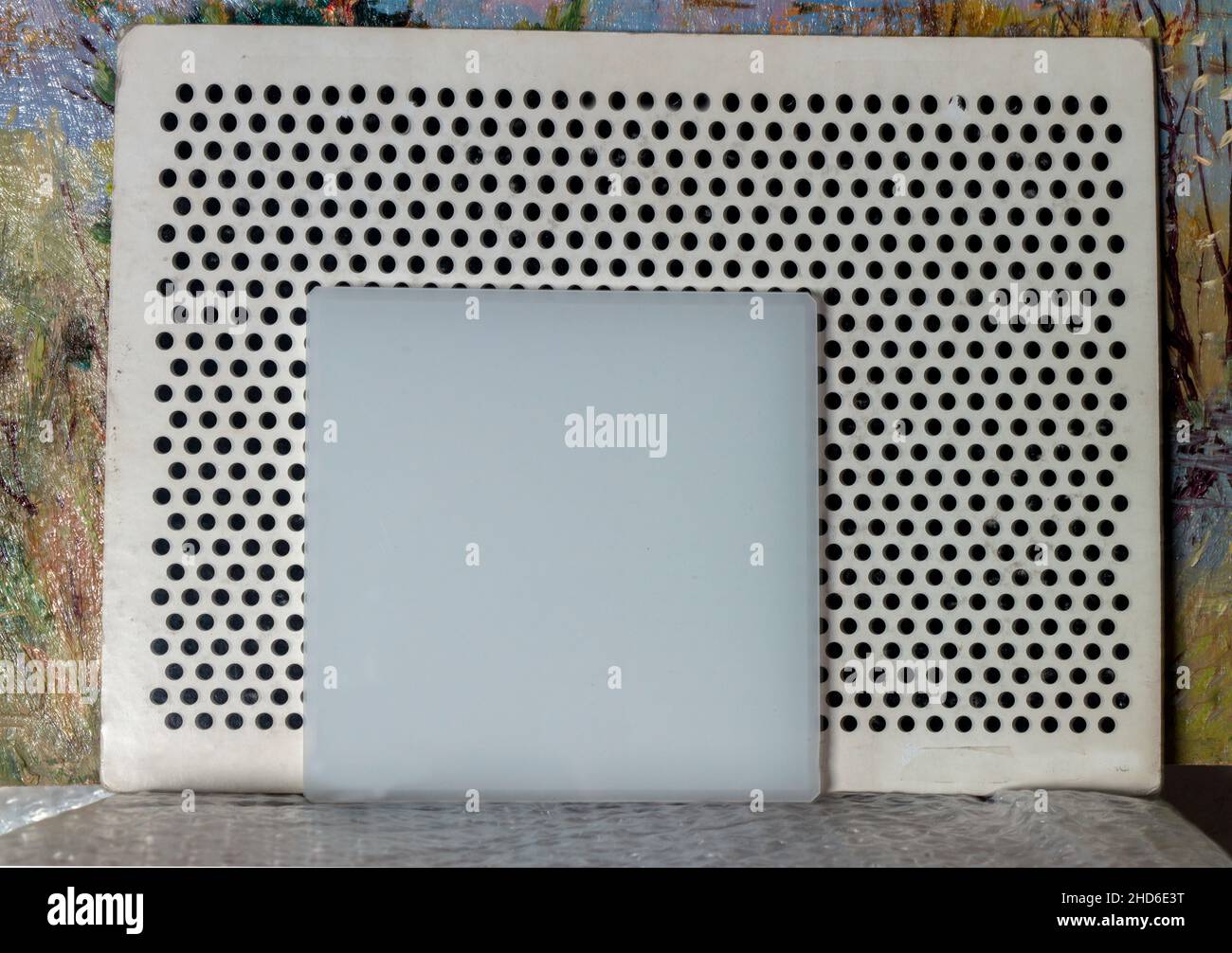 white balance checker in front of a canvas with abstract painting ...