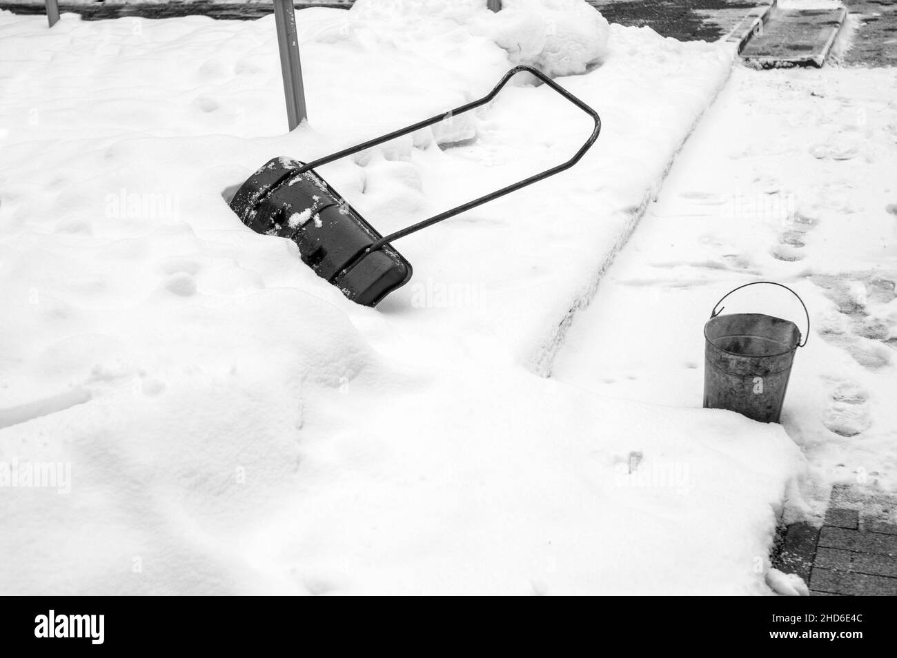 a bucket with salt for salt spreading and snow scraper, in black and ...