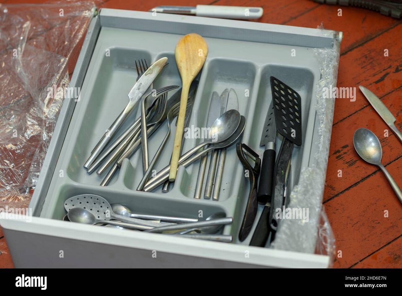 removed kitchen drawer with silverware on the floor, indoor close up ...