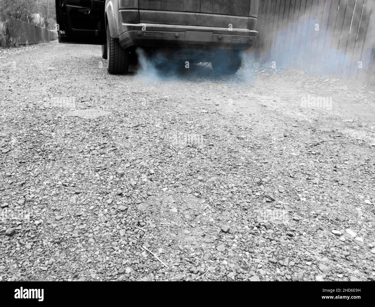 Rear of a vehicle with smoking car engine, outdoor selective color shot ...