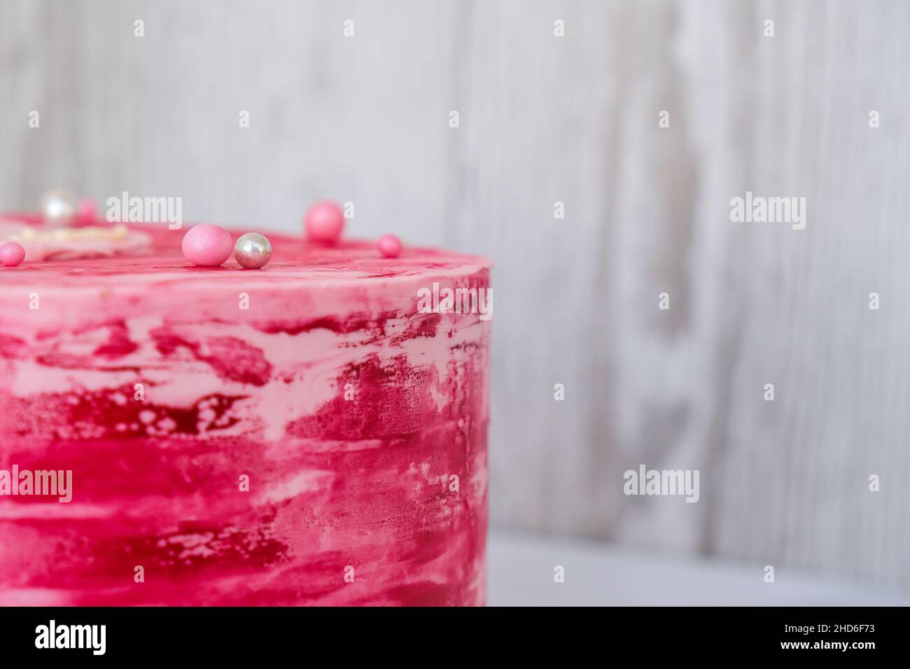 Side view of colorful pink birthday cake. Party celebration concept ...