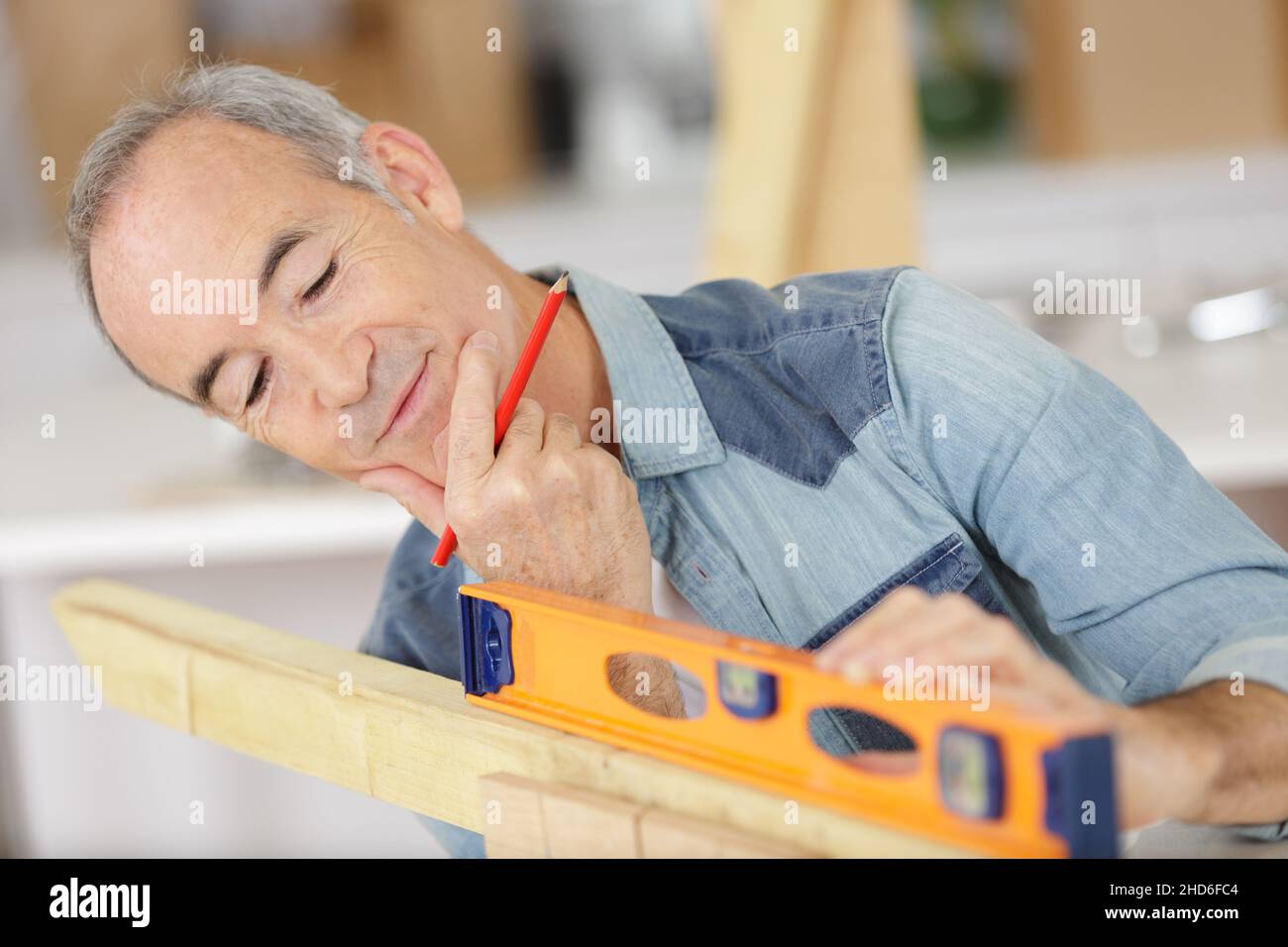 portrait of senior man with spirit level Stock Photo - Alamy