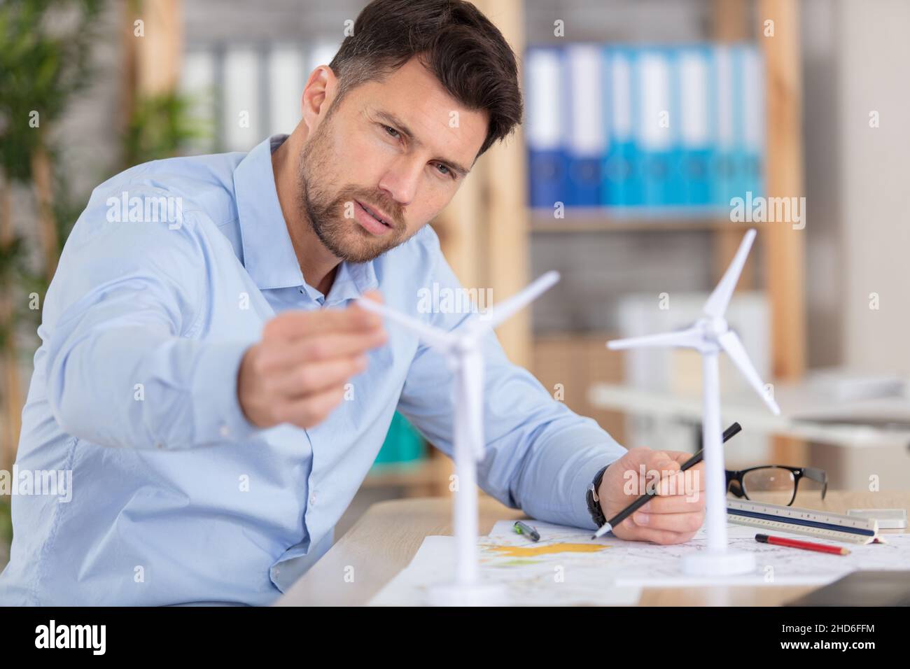 architect man working on blueprints for wind turbine implantation Stock ...