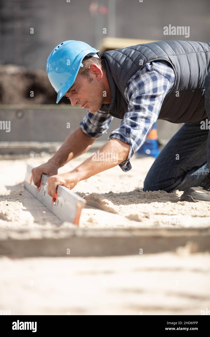 young builder leveling new concrete foundation Stock Photo - Alamy
