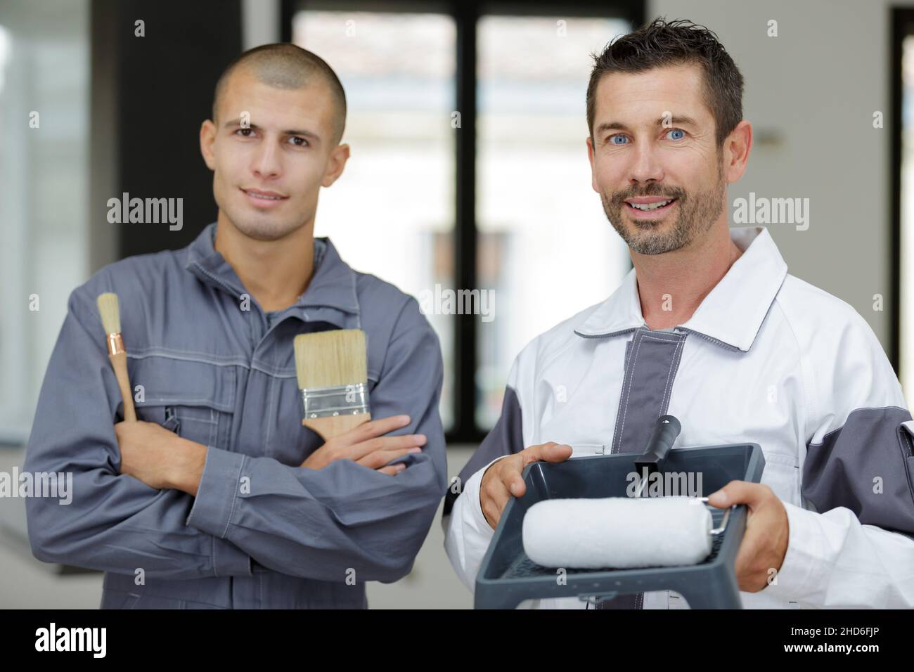 two professional male decorators holding paintbrush and roller Stock ...