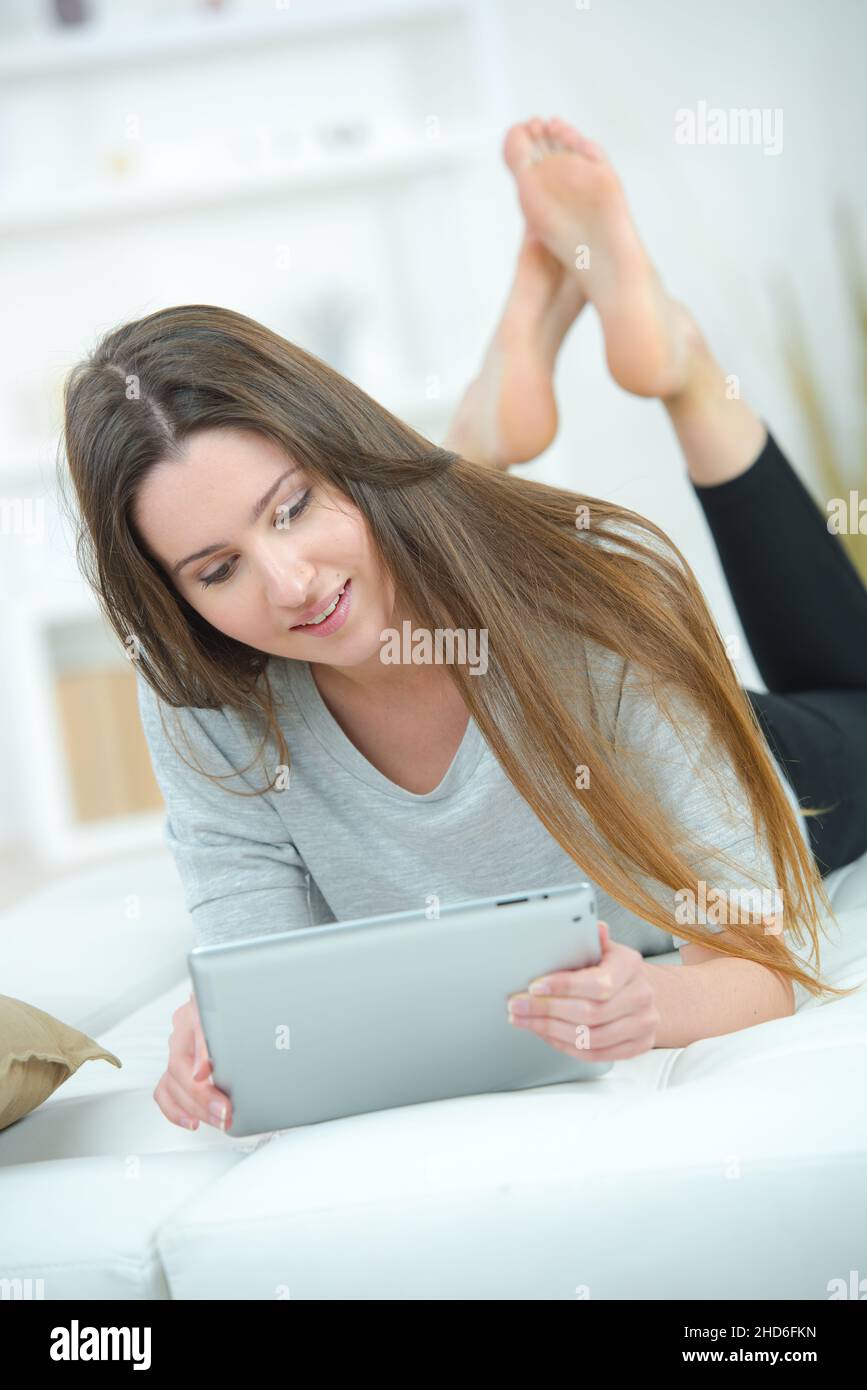 lazy young woman using computer tablet browsing internet Stock Photo ...
