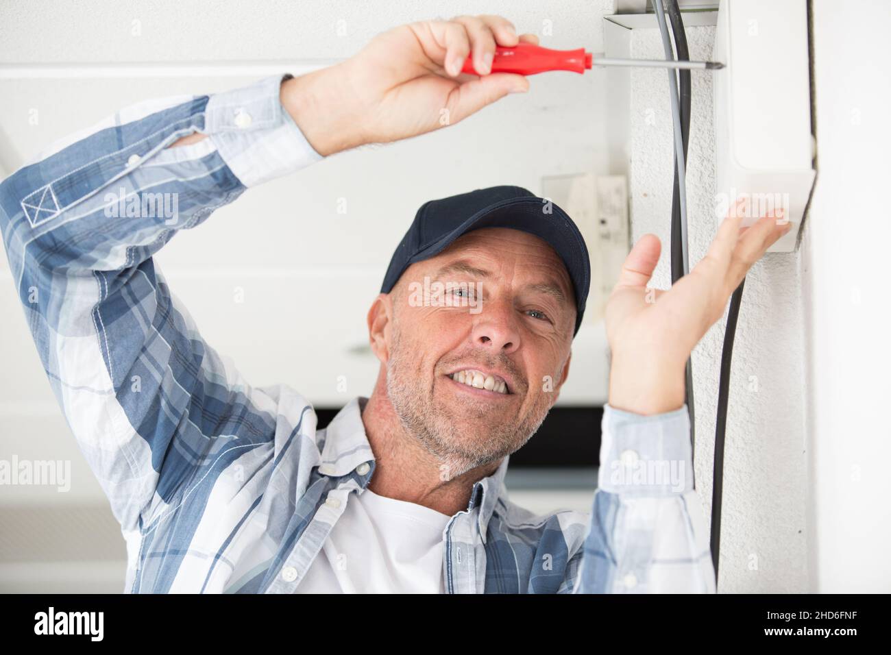 happy builder with screwdriver and cables Stock Photo - Alamy