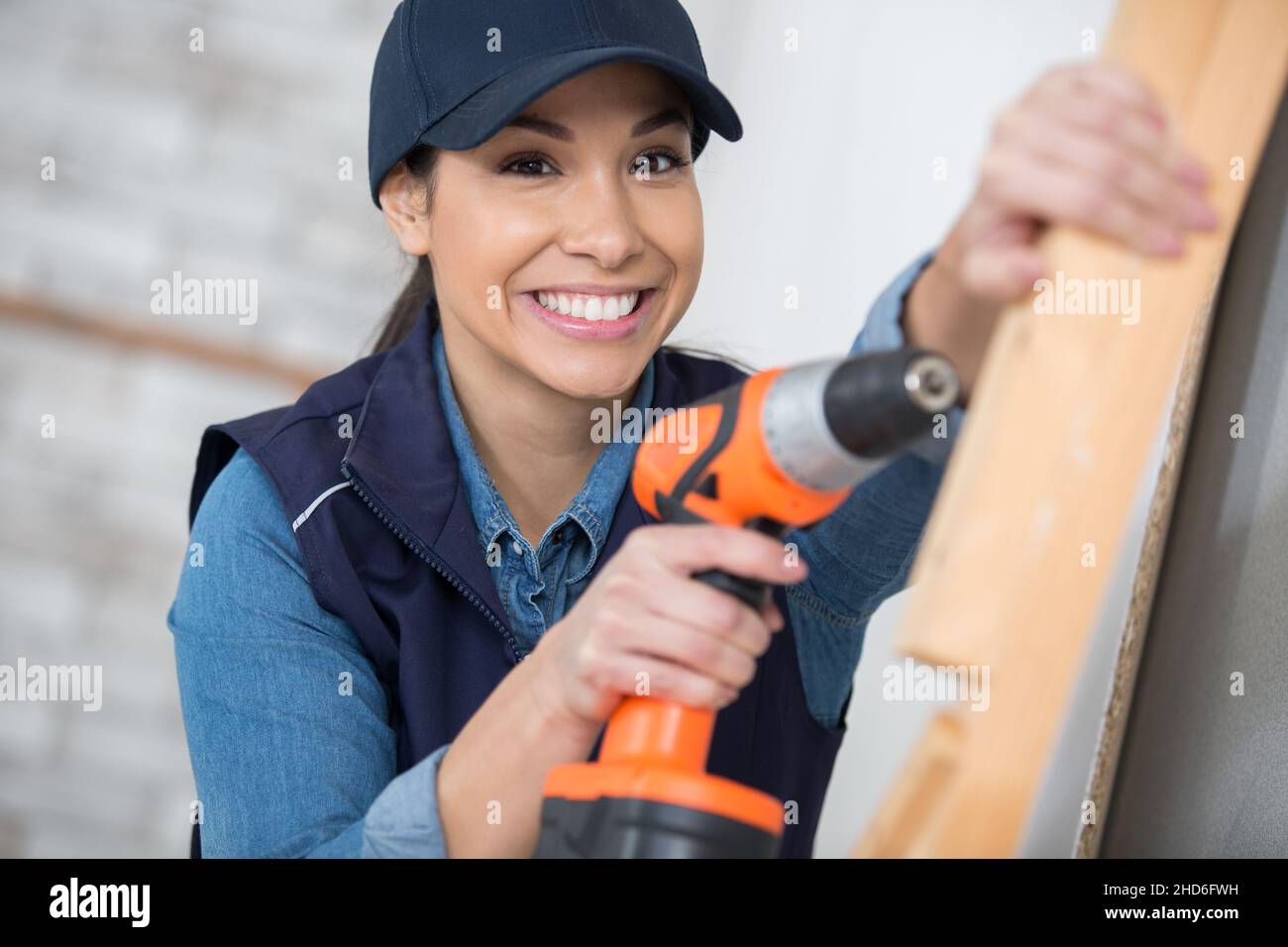 Woman builder using drill hi-res stock photography and images - Alamy