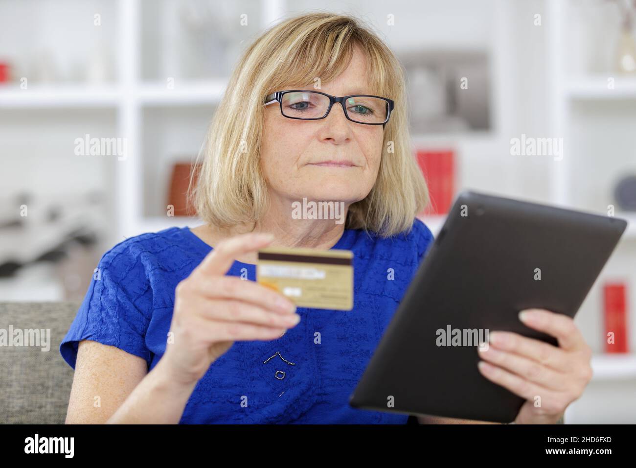 senior woman giving credit card on tablet Stock Photo - Alamy