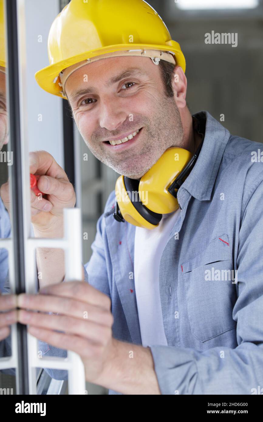 service man installing window with screwdriver Stock Photo - Alamy