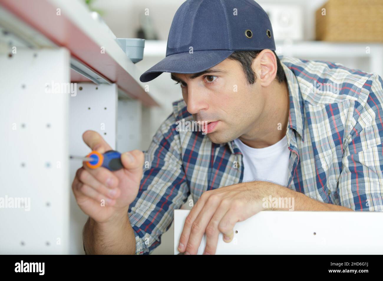 happy man screwing screws into furniture fittings Stock Photo - Alamy