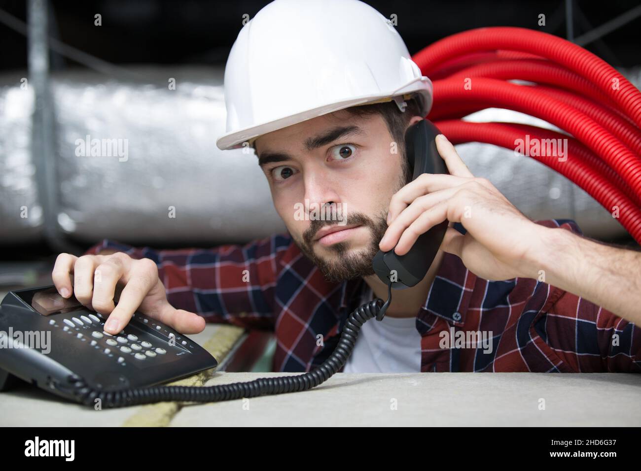 male contractor making strange expression while using telephone Stock ...