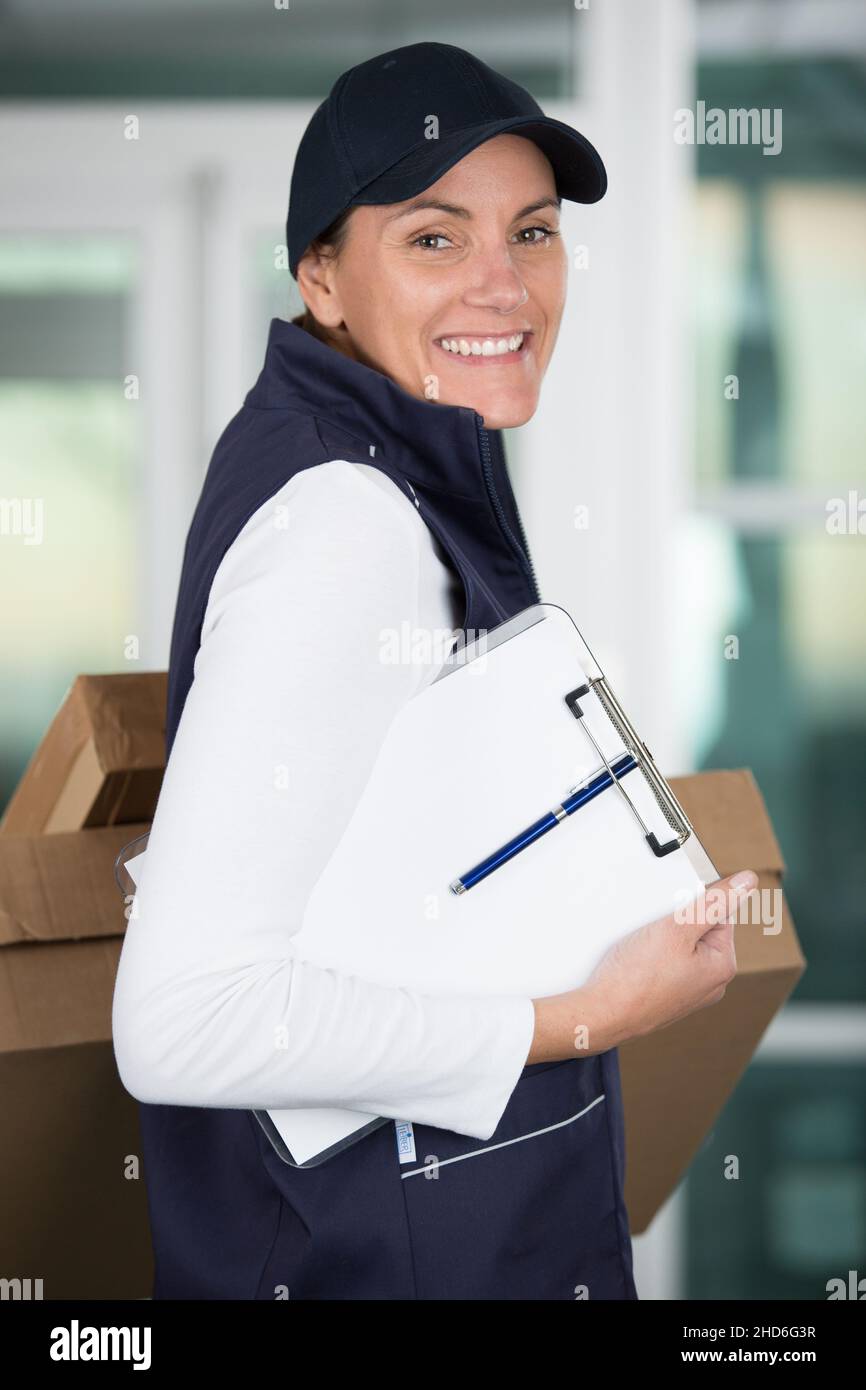 delivery woman in uniform holding package Stock Photo - Alamy